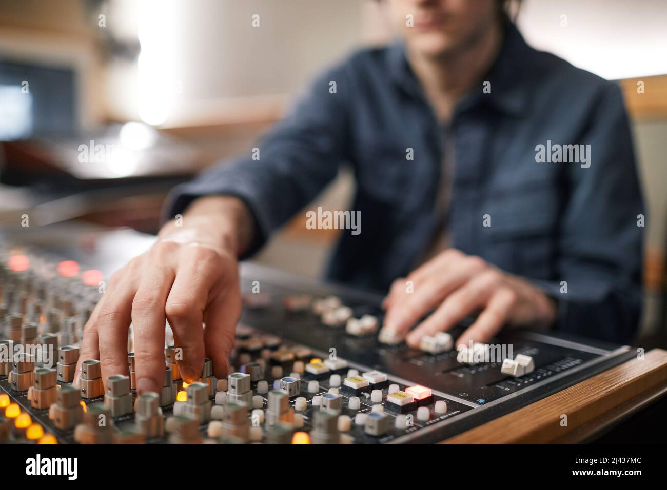Close up of male hands operating buttons and toggles at audio ...