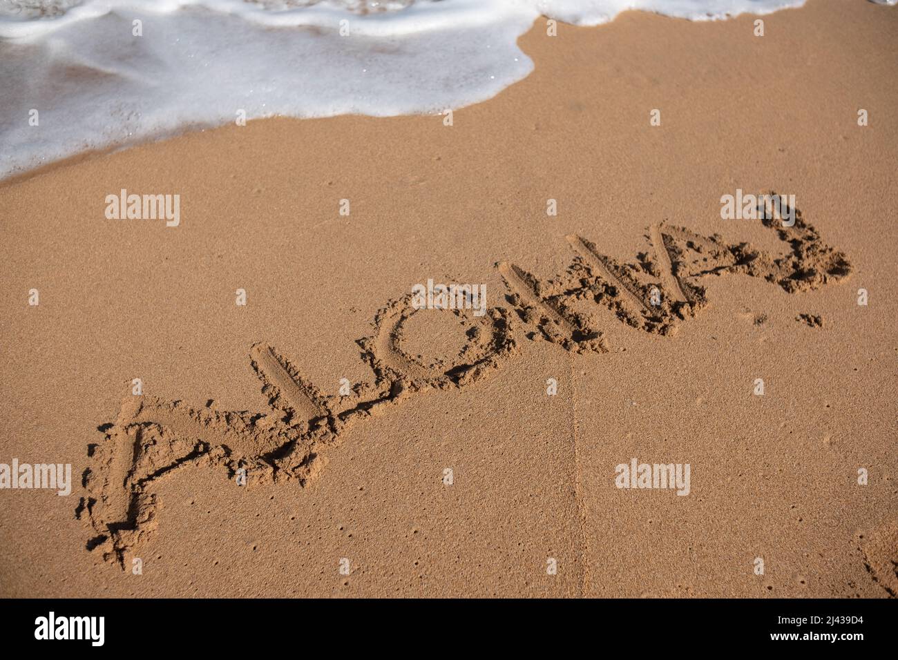 ALOHA written sand near waves Stock Photo - Alamy