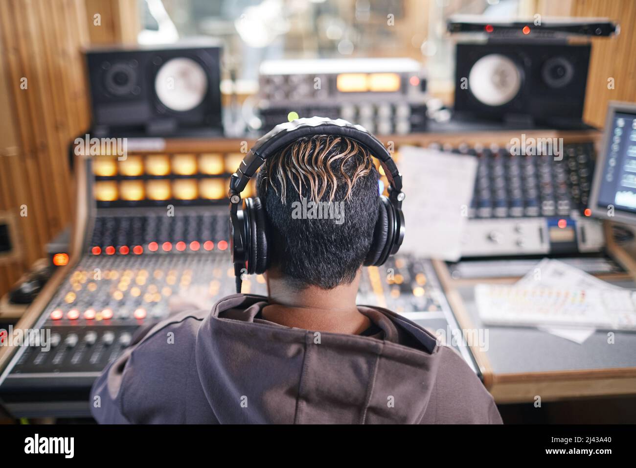 Back view at anonymous young musician wearing headphones in ...