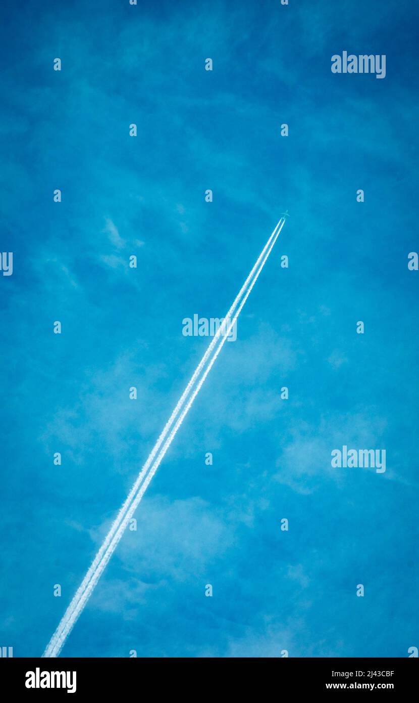 background the plane writes lines across the sky Stock Photo - Alamy