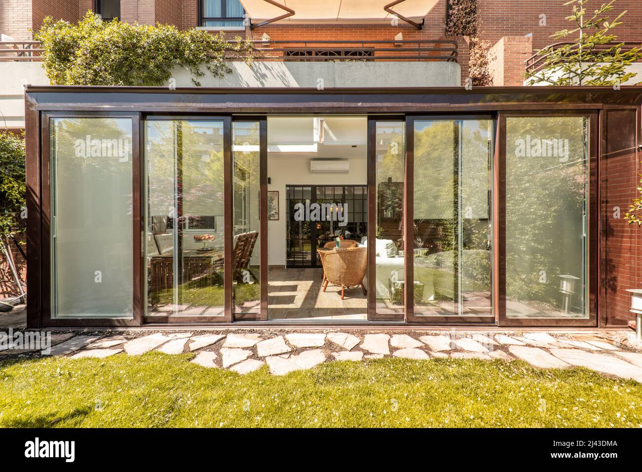 Covered terrace with brown aluminum structure and glass with access to ...