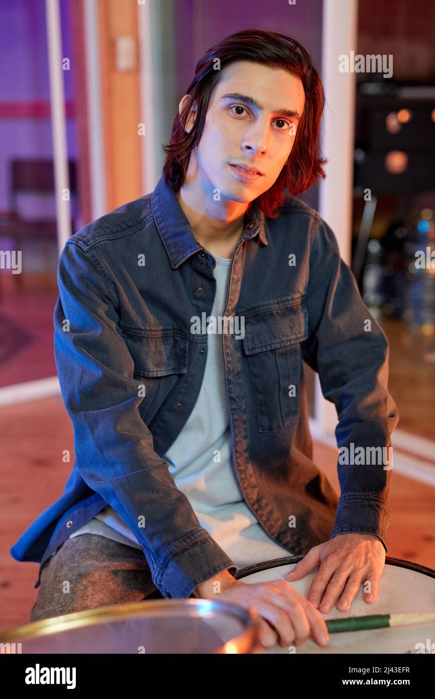 Vertical portrait of talented young drummer in recording studio by drum ...