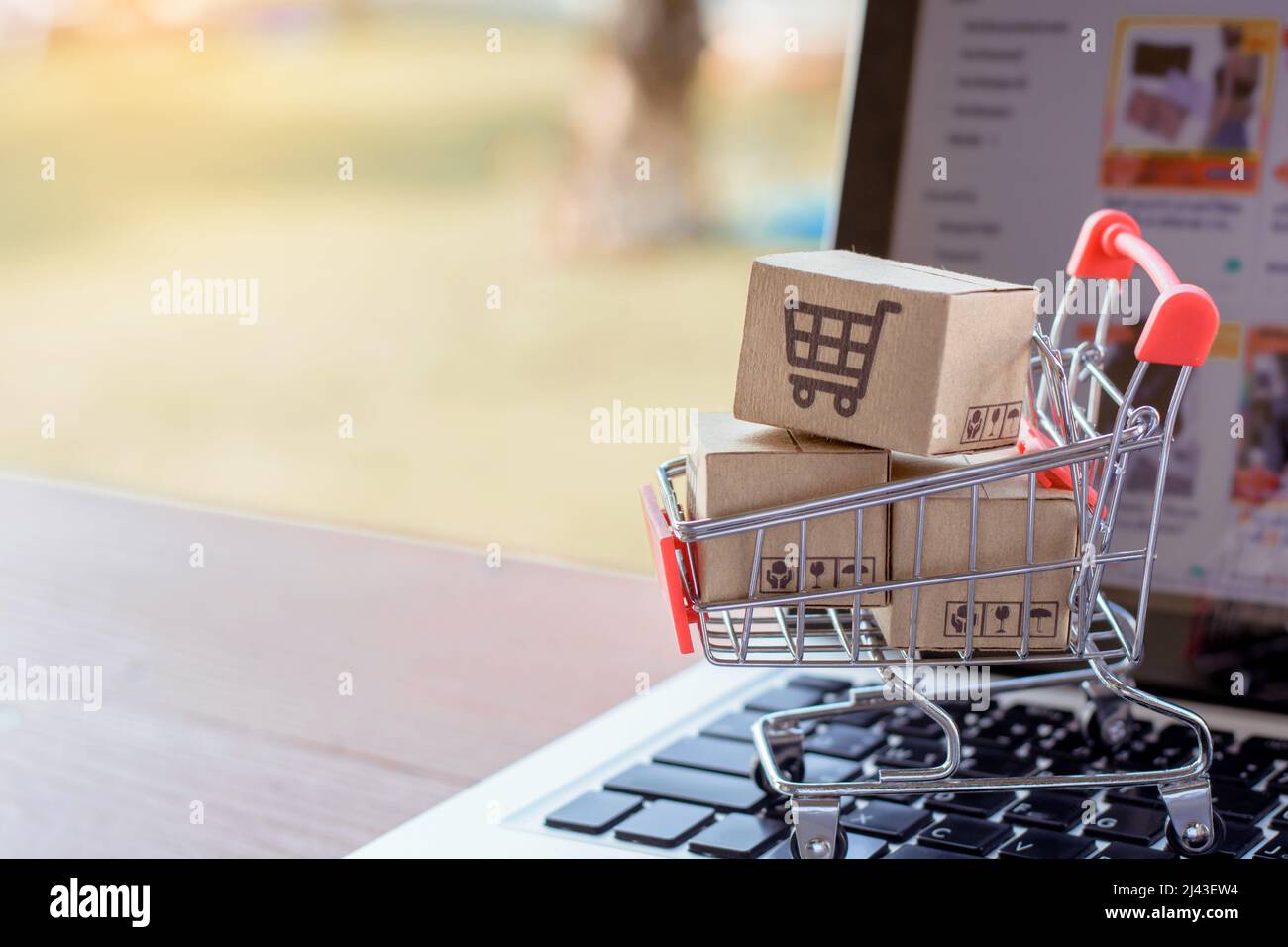 Shopping online. cardboard box with a shopping cart logo in a trolley ...
