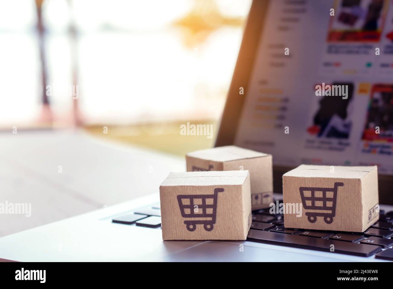 Shopping online. Cardboard box with a shopping cart logo on laptop ...