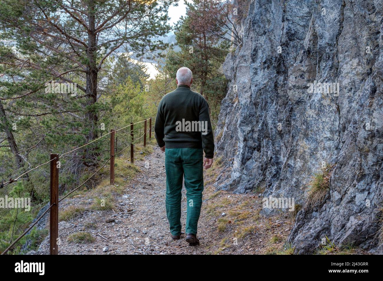 A mountain hiker walks a narrow, steep serpentine path on the Sass ...