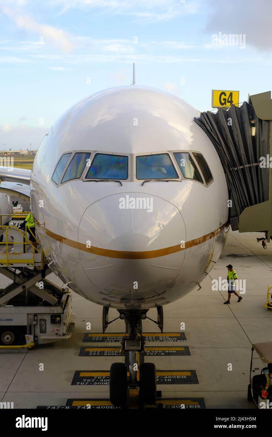 Front view of an airplane being serviced, loaded and attached to ...