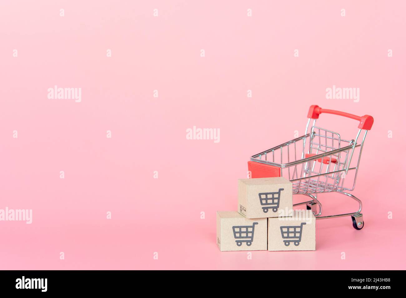 Shopping concept : Cartons or Paper boxes in red shopping cart on pink ...
