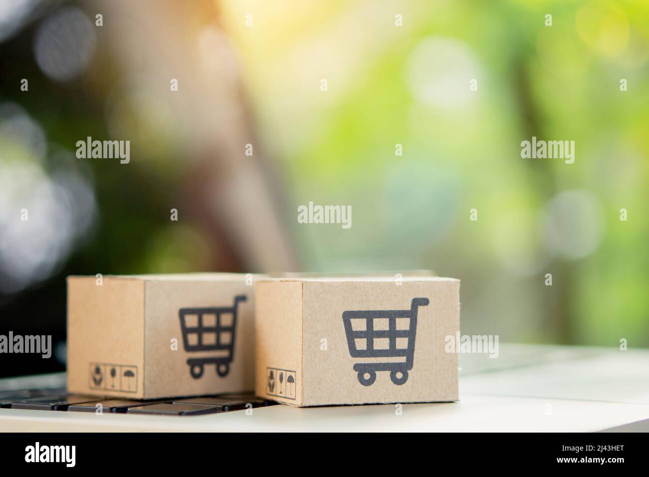 Shopping online. Cardboard box with a shopping cart logo on laptop ...