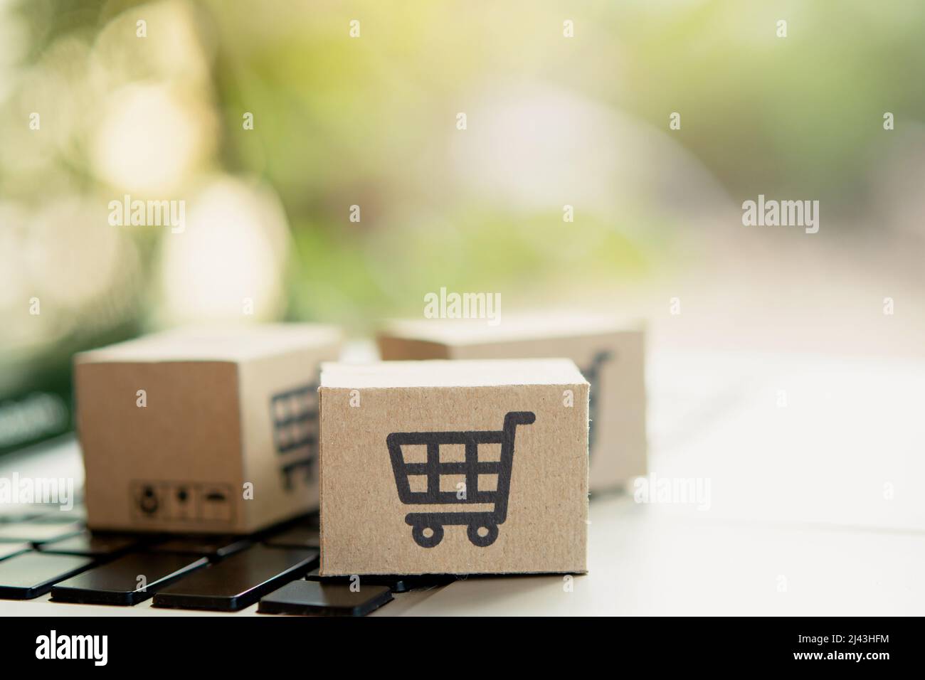 Shopping online. Cardboard box with a shopping cart logo on laptop ...