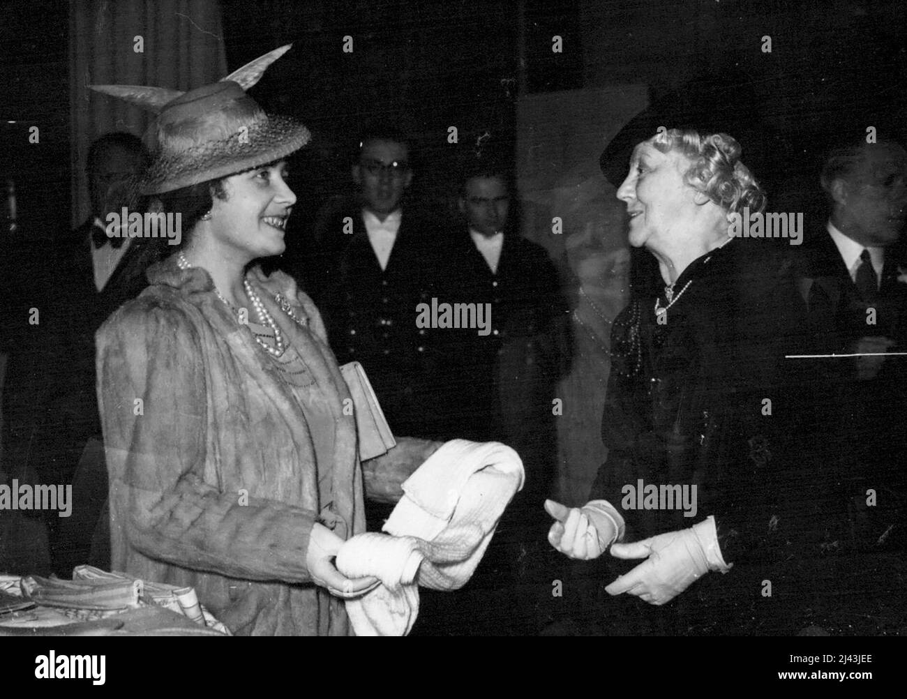 Queen Visits Red Cross Depot at Mansion House The Queen holding a pair ...