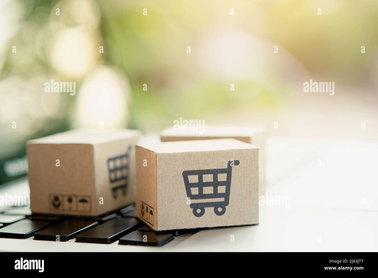 Shopping online. Cardboard box with a shopping cart logo on laptop ...