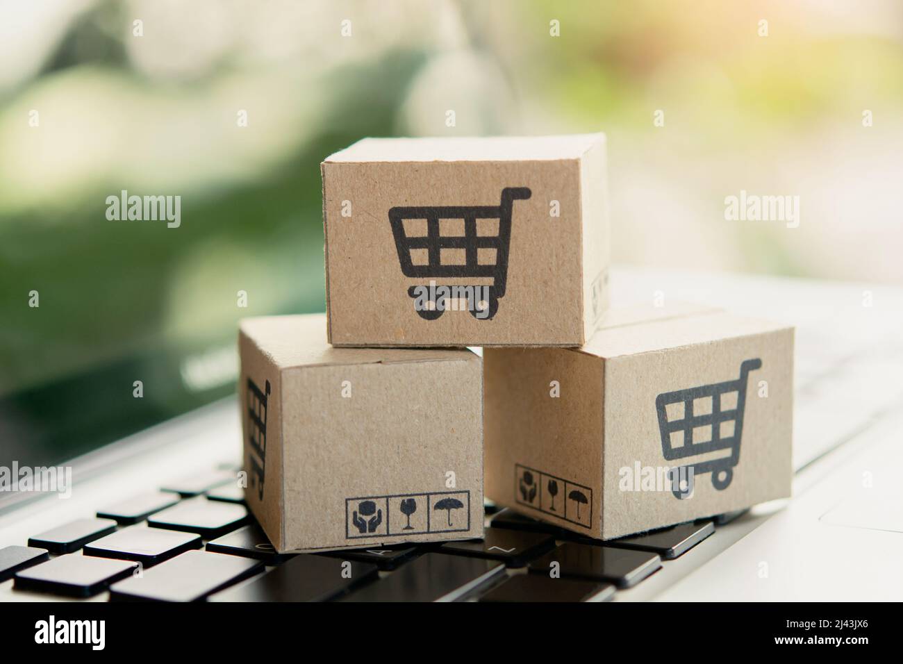 Shopping online. Cardboard box with a shopping cart logo on laptop ...