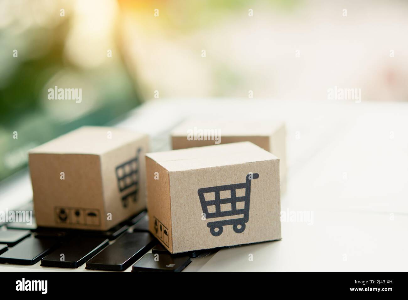 Shopping online. Cardboard box with a shopping cart logo on laptop ...