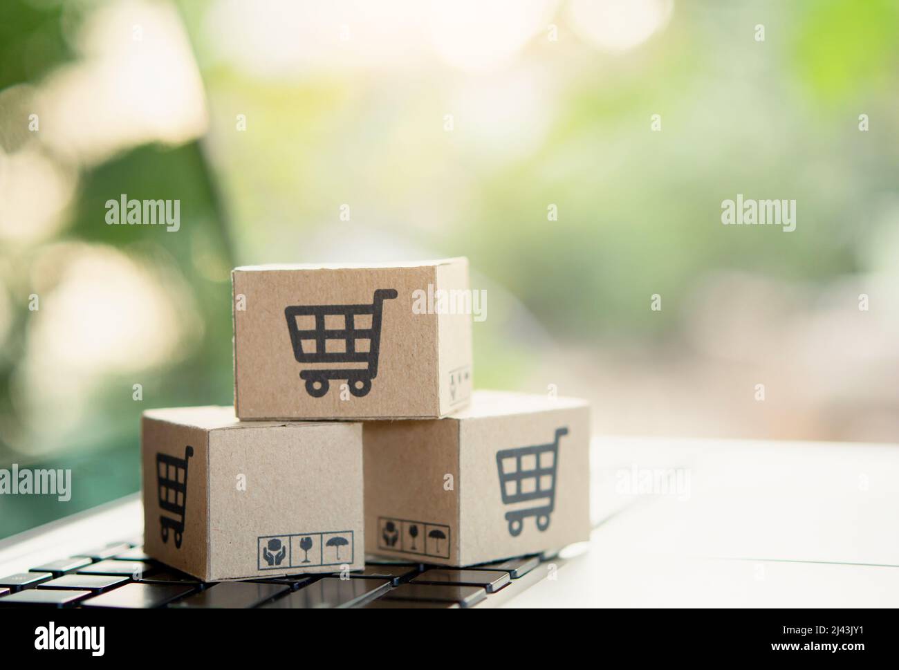 Shopping online. Cardboard box with a shopping cart logo on laptop ...