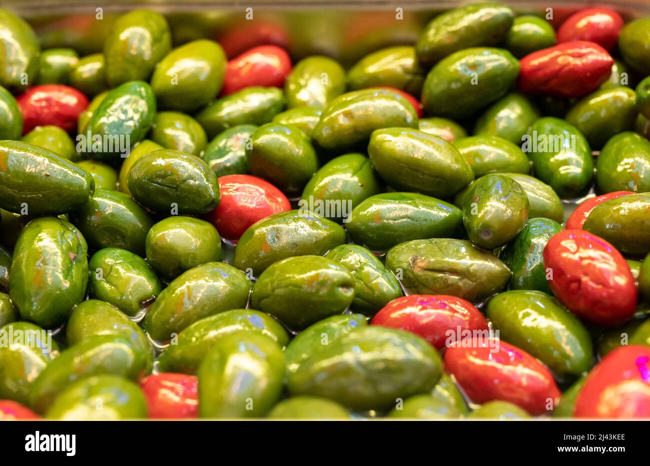 Tasty green and red olives close up on market, healthy vegetarian food ...