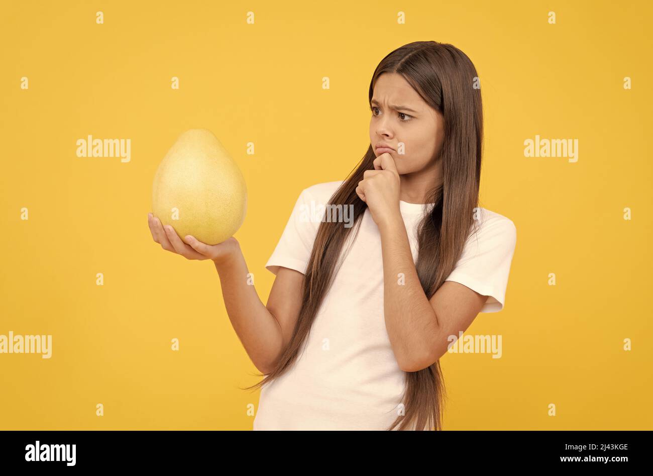 serious kid girl hold big citrus fruit of yellow pummelo or pomelo full ...