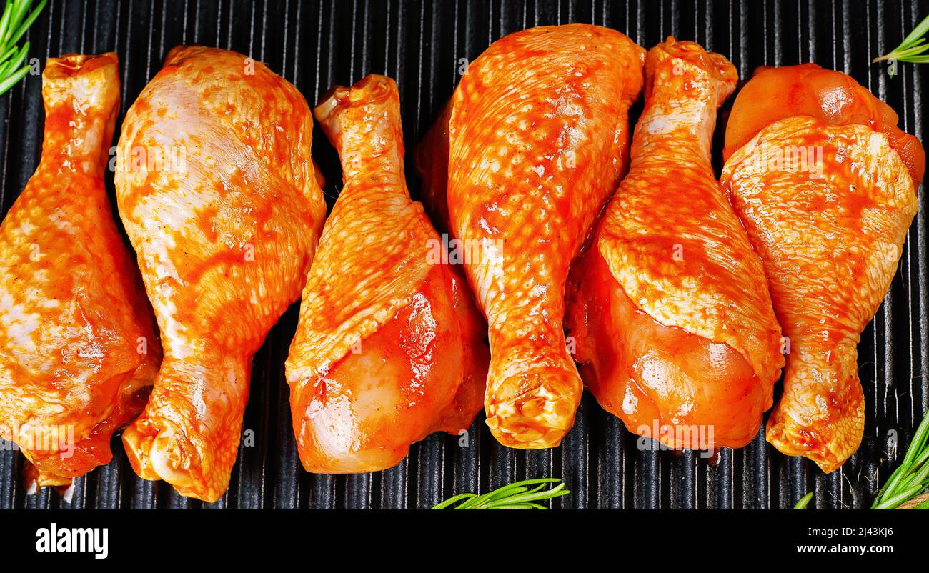 Barbecue marinated chicken dramstick on a black culinary board on a ...