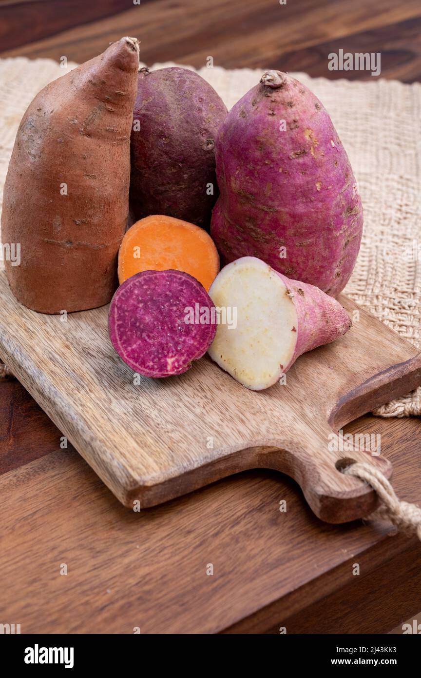 Colorful root vegetables pink, purple and orange organic sweet potatos ...