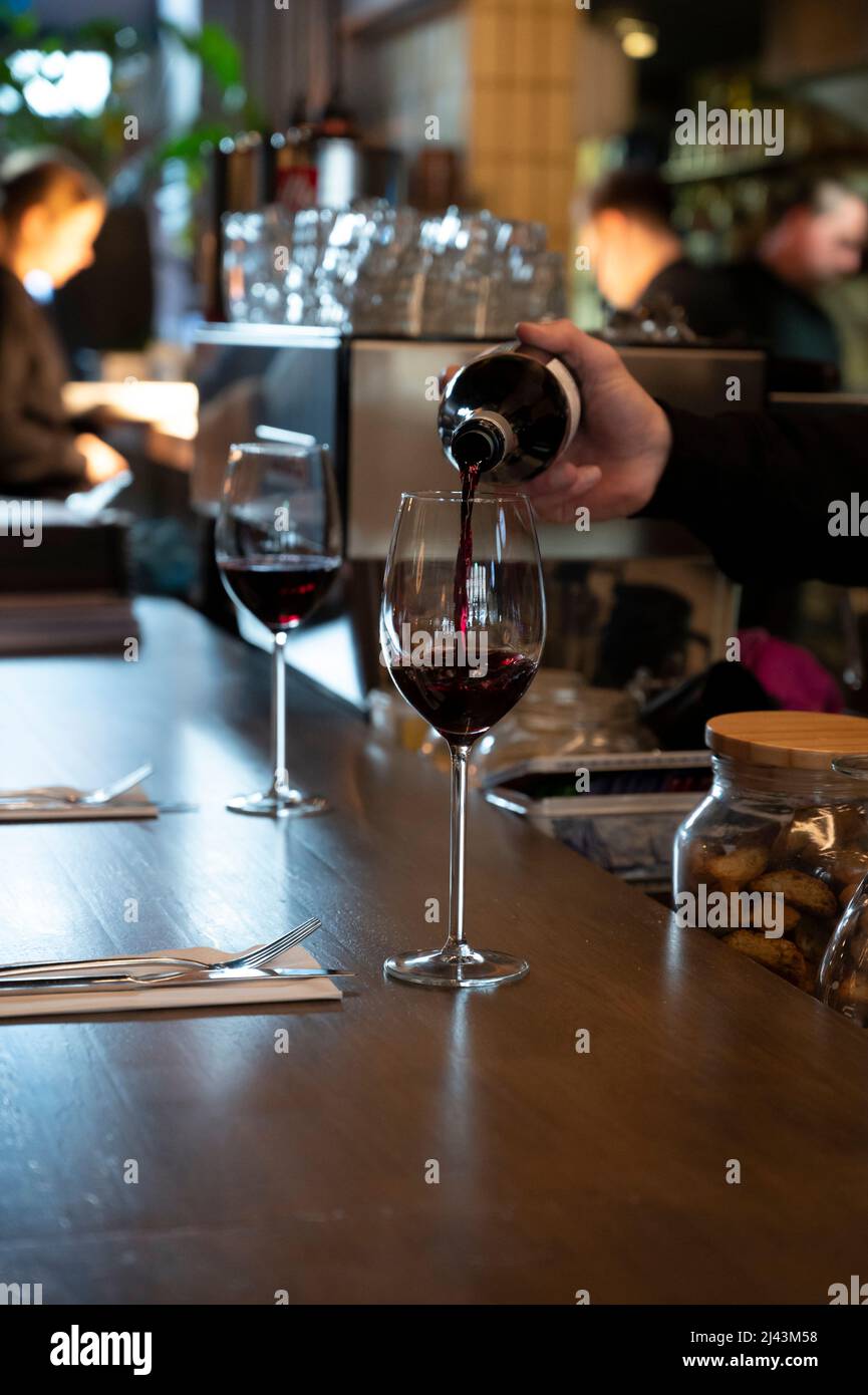 Pouring of dry Spanish tempranillo red wine in glass in Spanish bogeda ...
