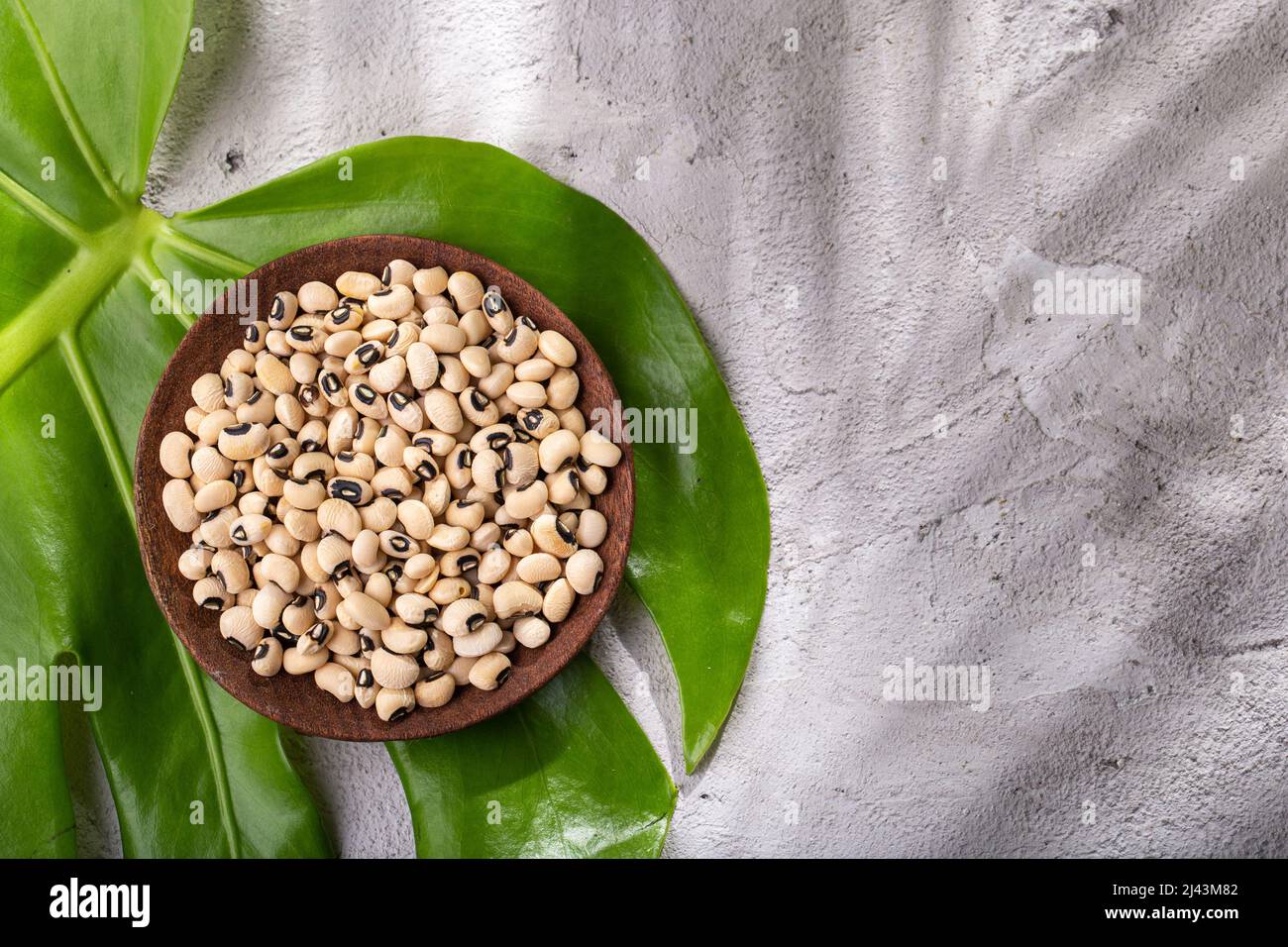 pile of black-eyed beans, in container on concrete surface- lubiya ...