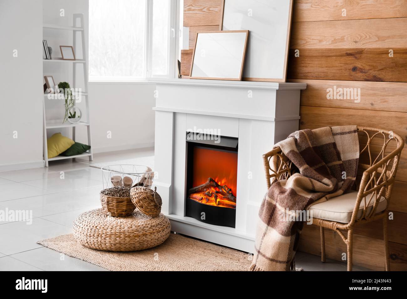 Interior of modern living room with mantelpiece, firewood and frames ...