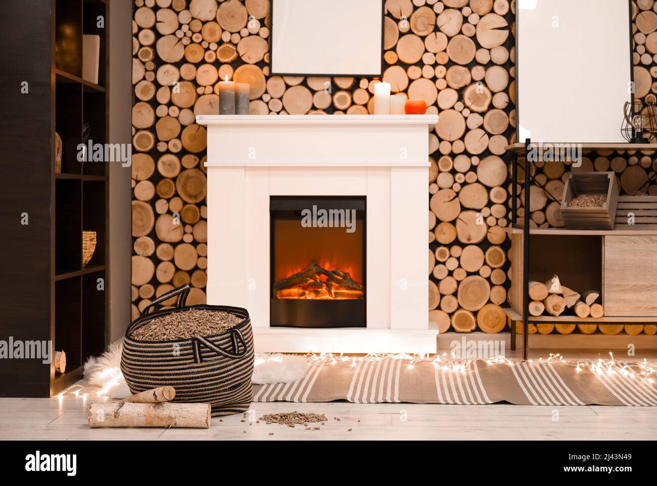 Interior of modern living room with mantelpiece, firewood and shelving ...