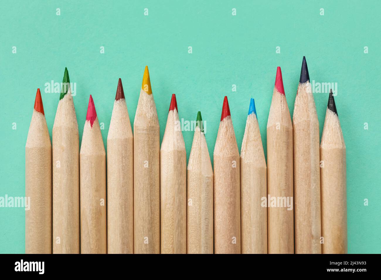 Colorful pencils on turquoise background Stock Photo - Alamy