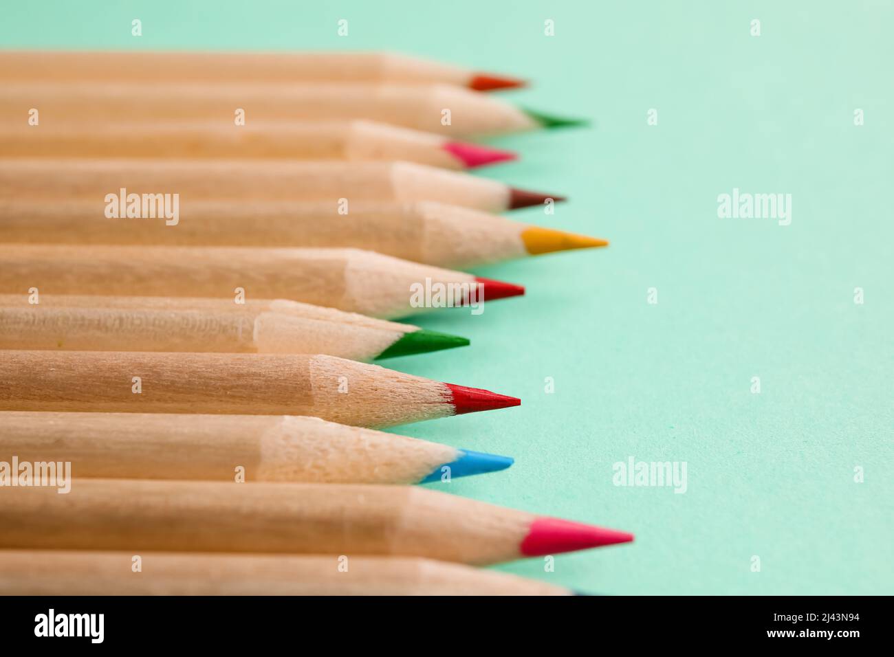 Colorful pencils on turquoise background Stock Photo - Alamy