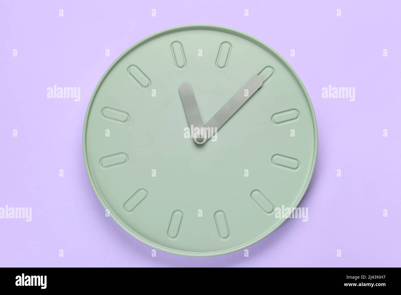 New modern clock on purple background Stock Photo - Alamy