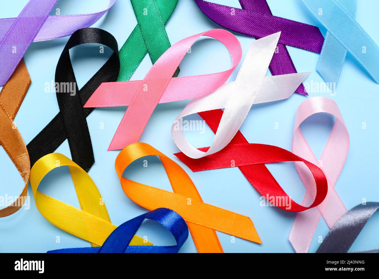 Different awareness ribbons on blue background, closeup. World Cancer ...