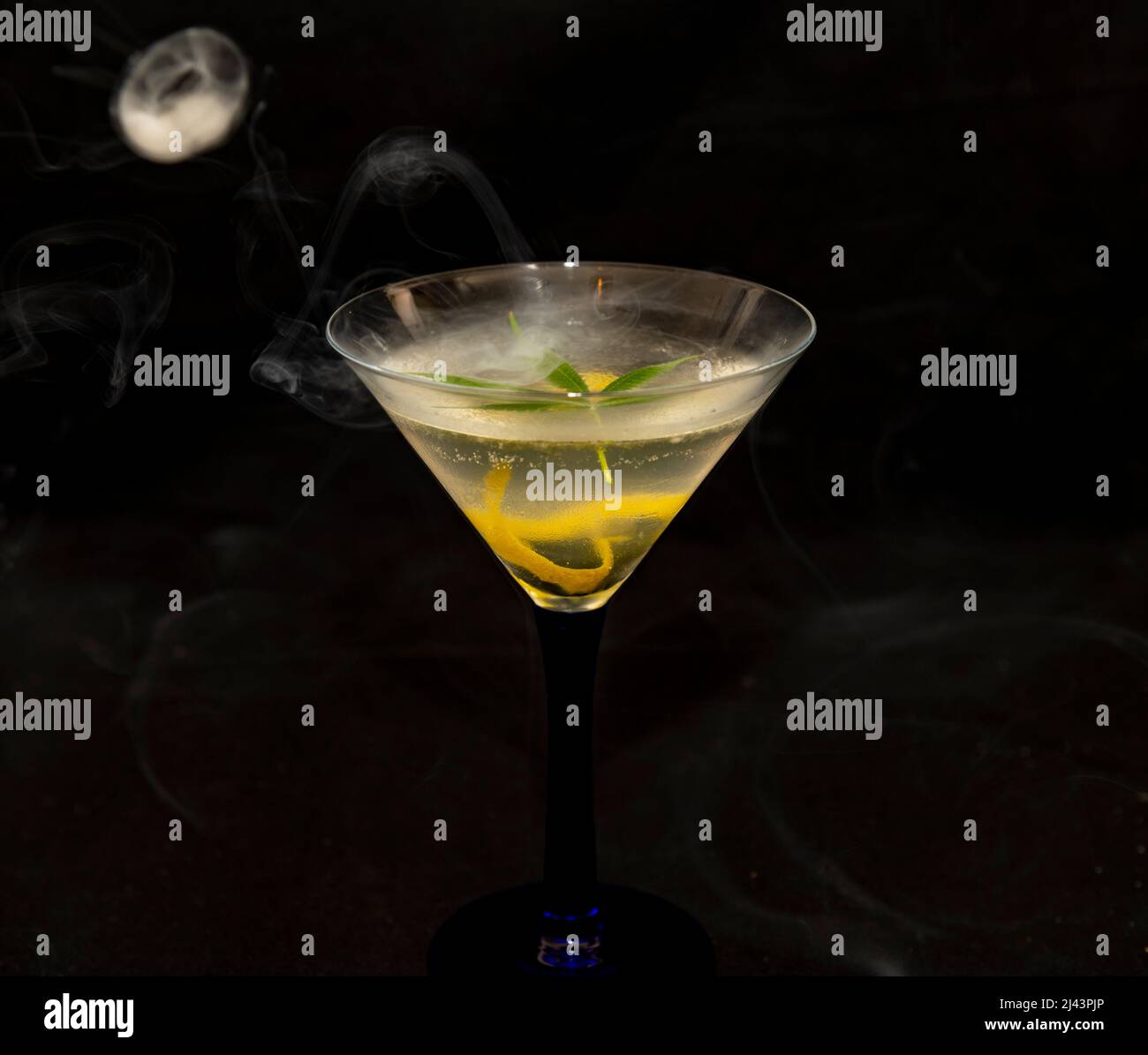 Cannabis infused martini cocktail with leaf and lemon rind isolated ...