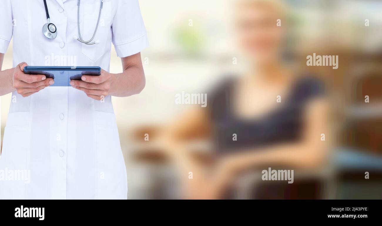 Mid section of caucasian female doctor using digital tablet against ...