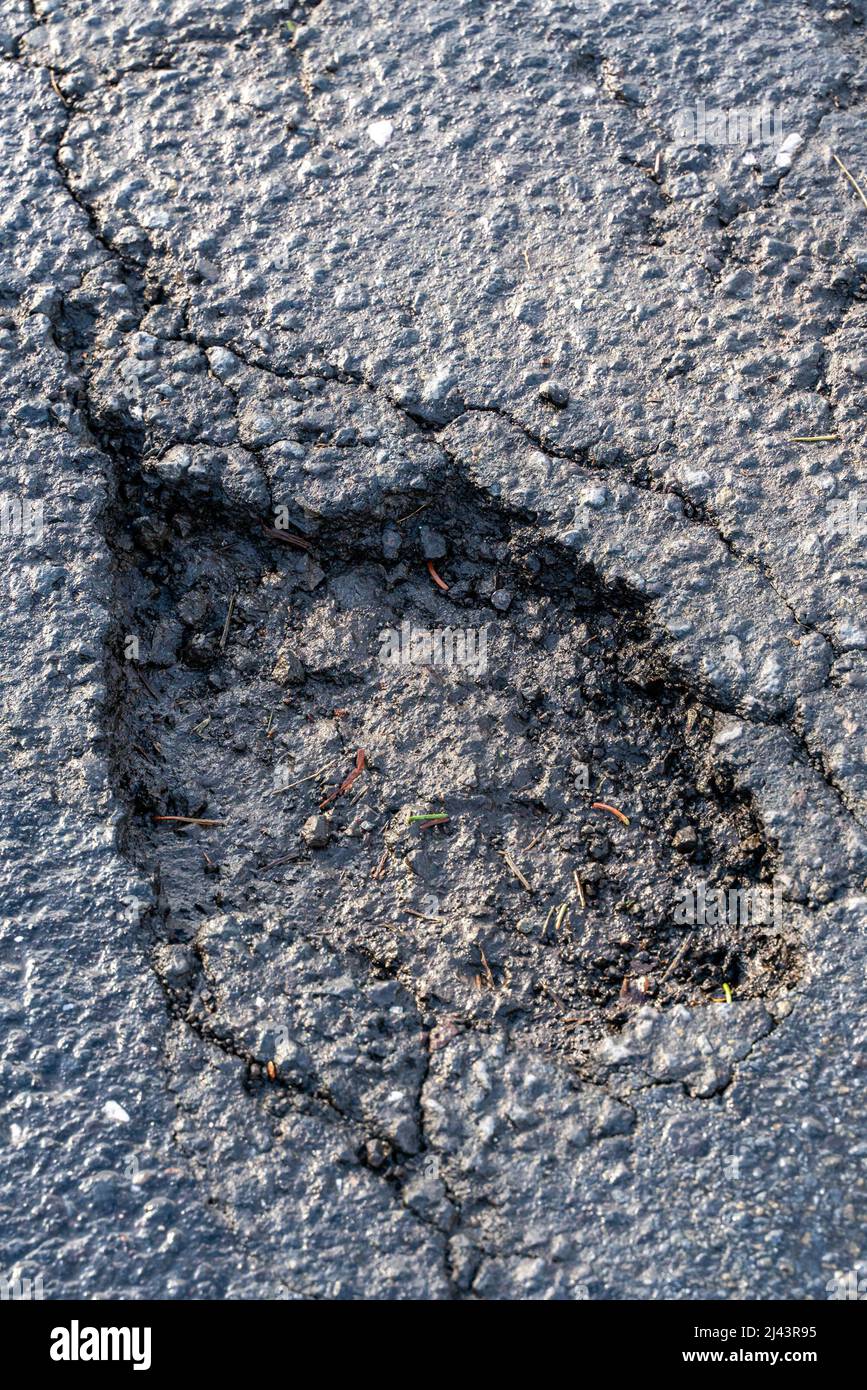 Pot hole in asphalt road. Damaged highway with hole in it. Dangerous ...