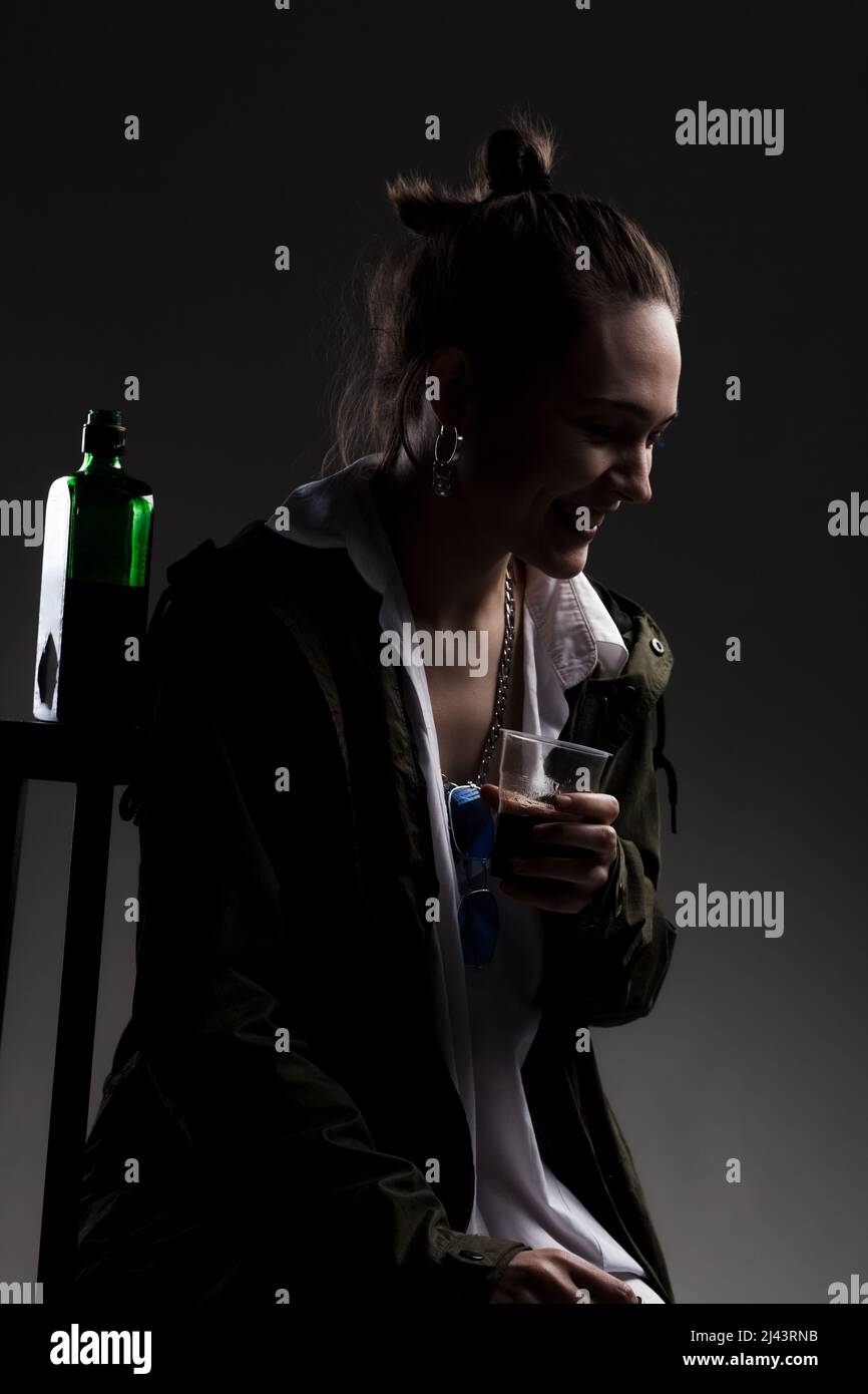studio portrait of a beautiful girl with alcohol bottle and a plastic ...