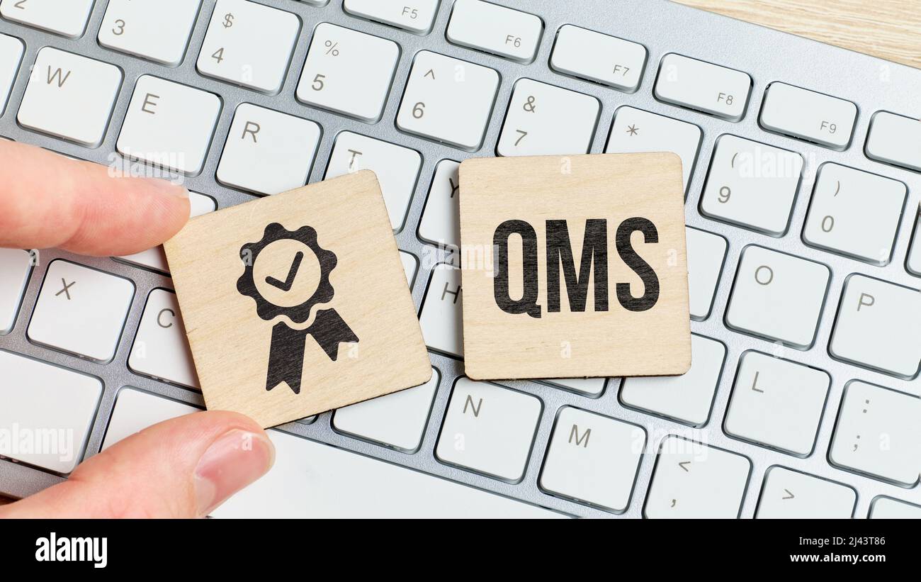 Acronym QMS or Quality Management System. Text with an icon on a piece ...