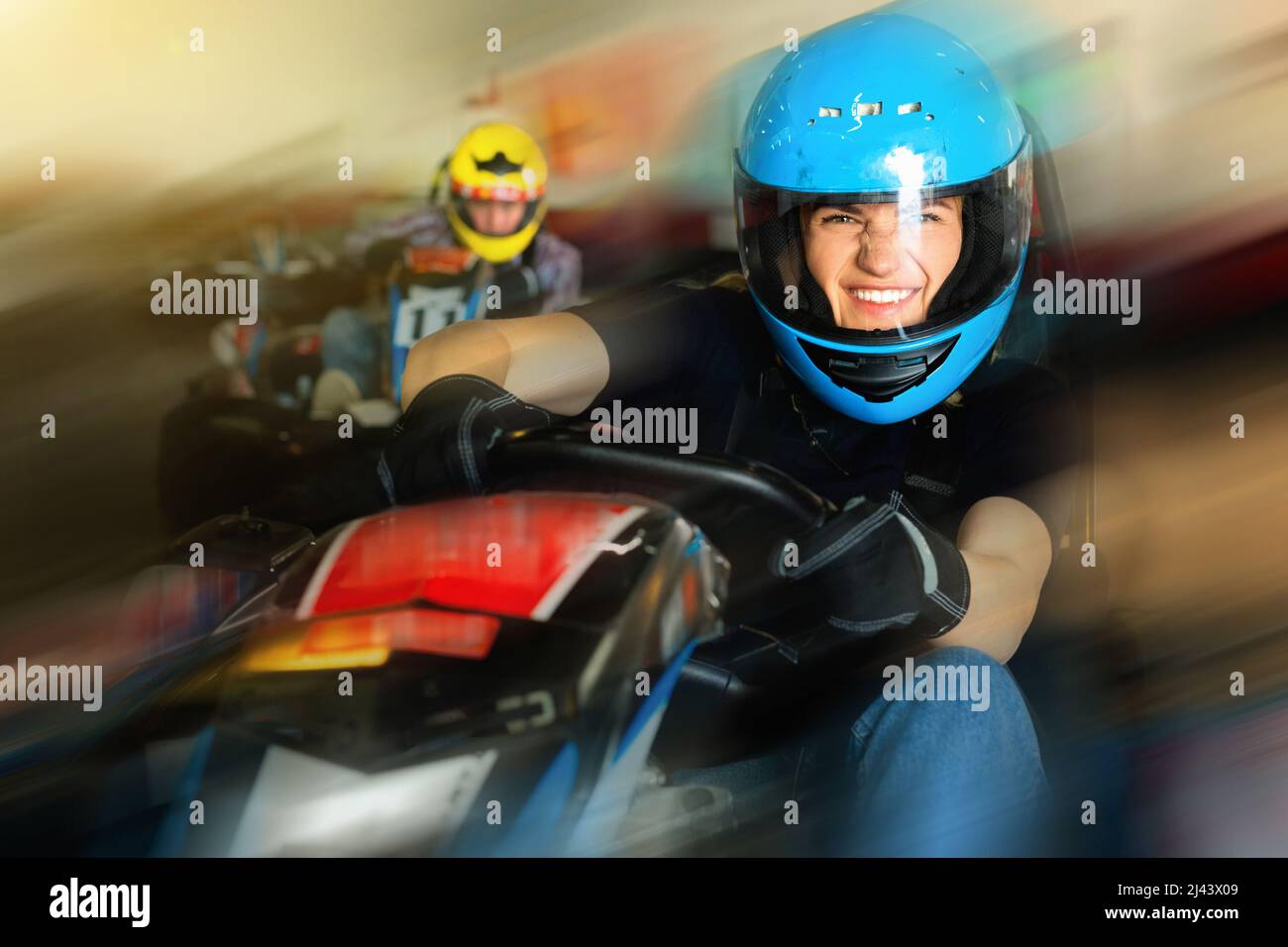 Girl and her friends competing on racing cars at kart circuit Stock ...