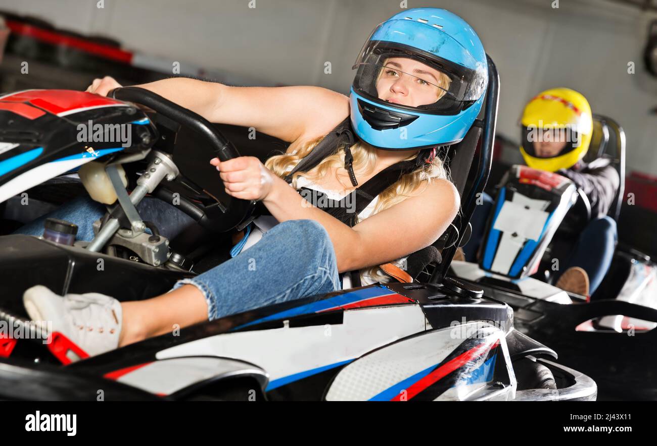 Female racer in helmet driving kart on track Stock Photo - Alamy
