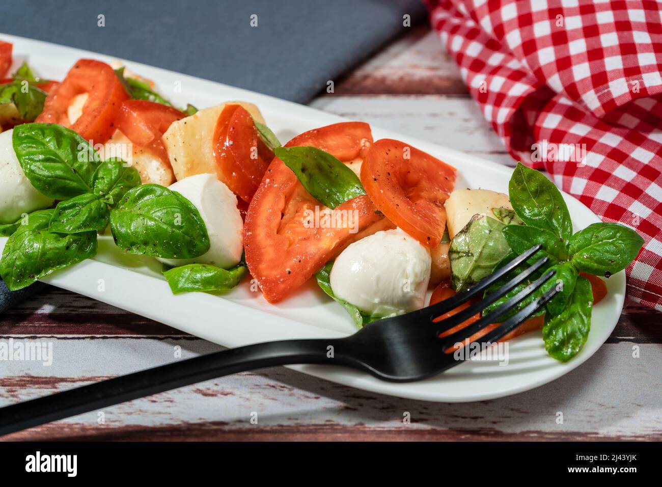 Classic Italian caprese salad of mozzarella, tomato and basil with ...