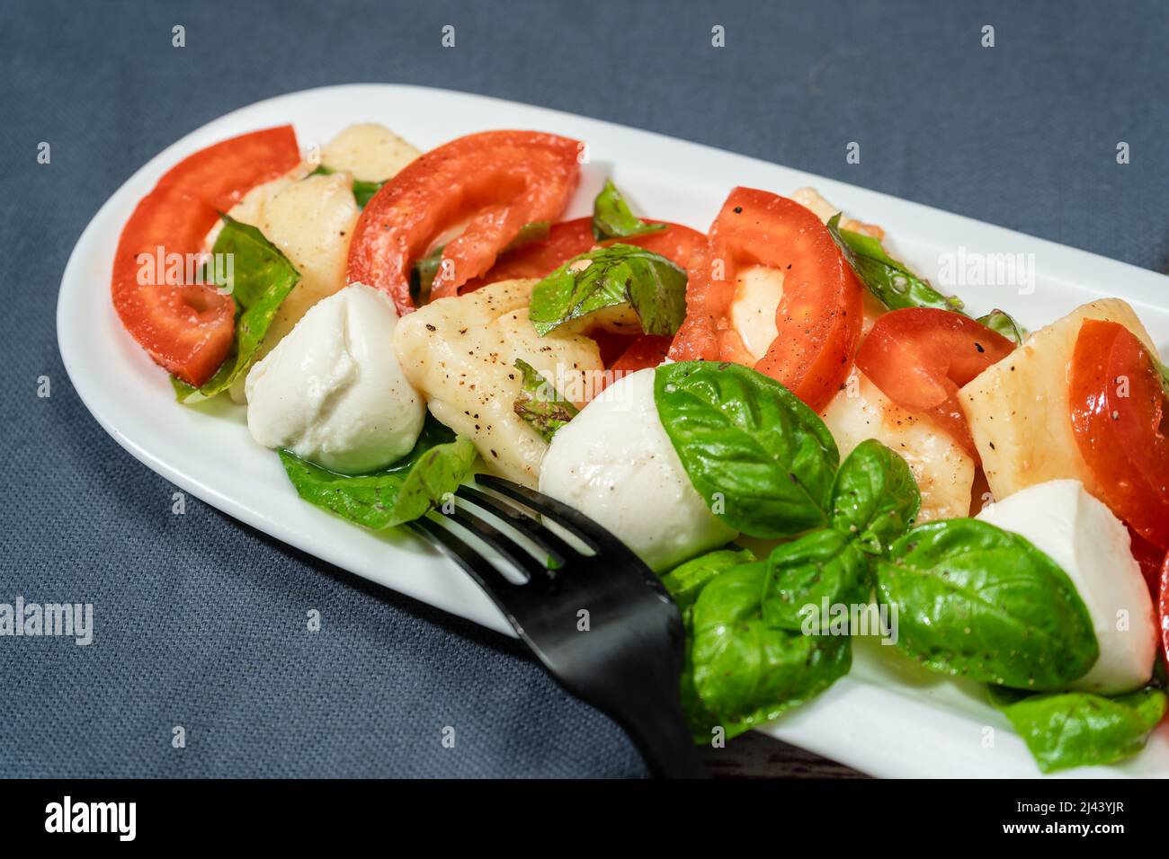 Classic Italian caprese salad of mozzarella, tomato and basil with ...