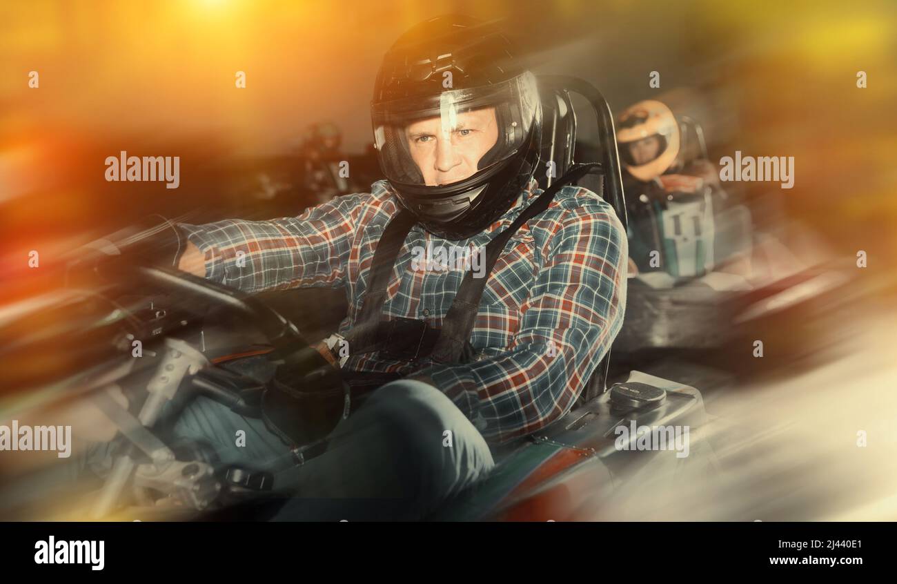 Man and his friends competing on racing cars Stock Photo - Alamy