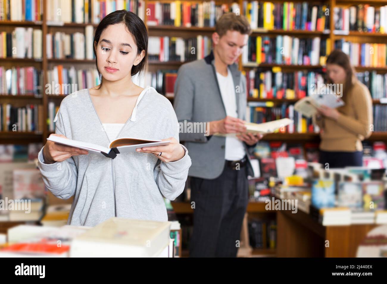 Girl reading books in library Stock Photo - Alamy