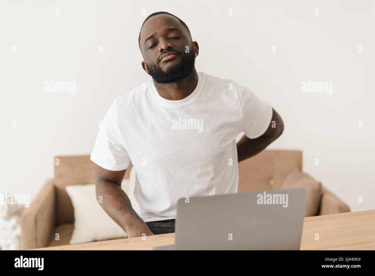 Backache. African american man suffering from low back pain from ...