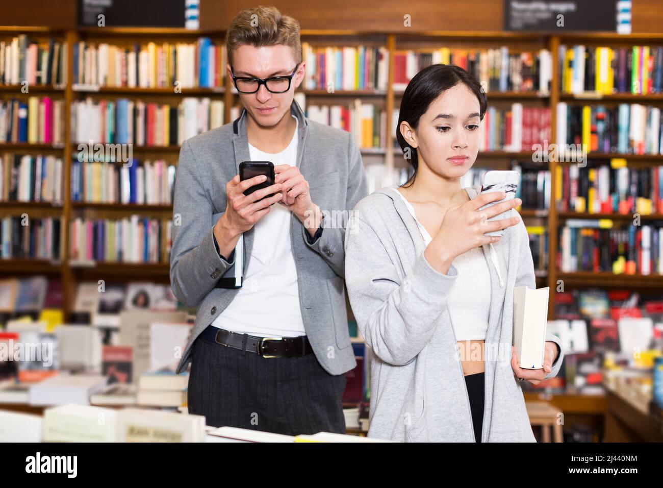 students using phones in library Stock Photo - Alamy