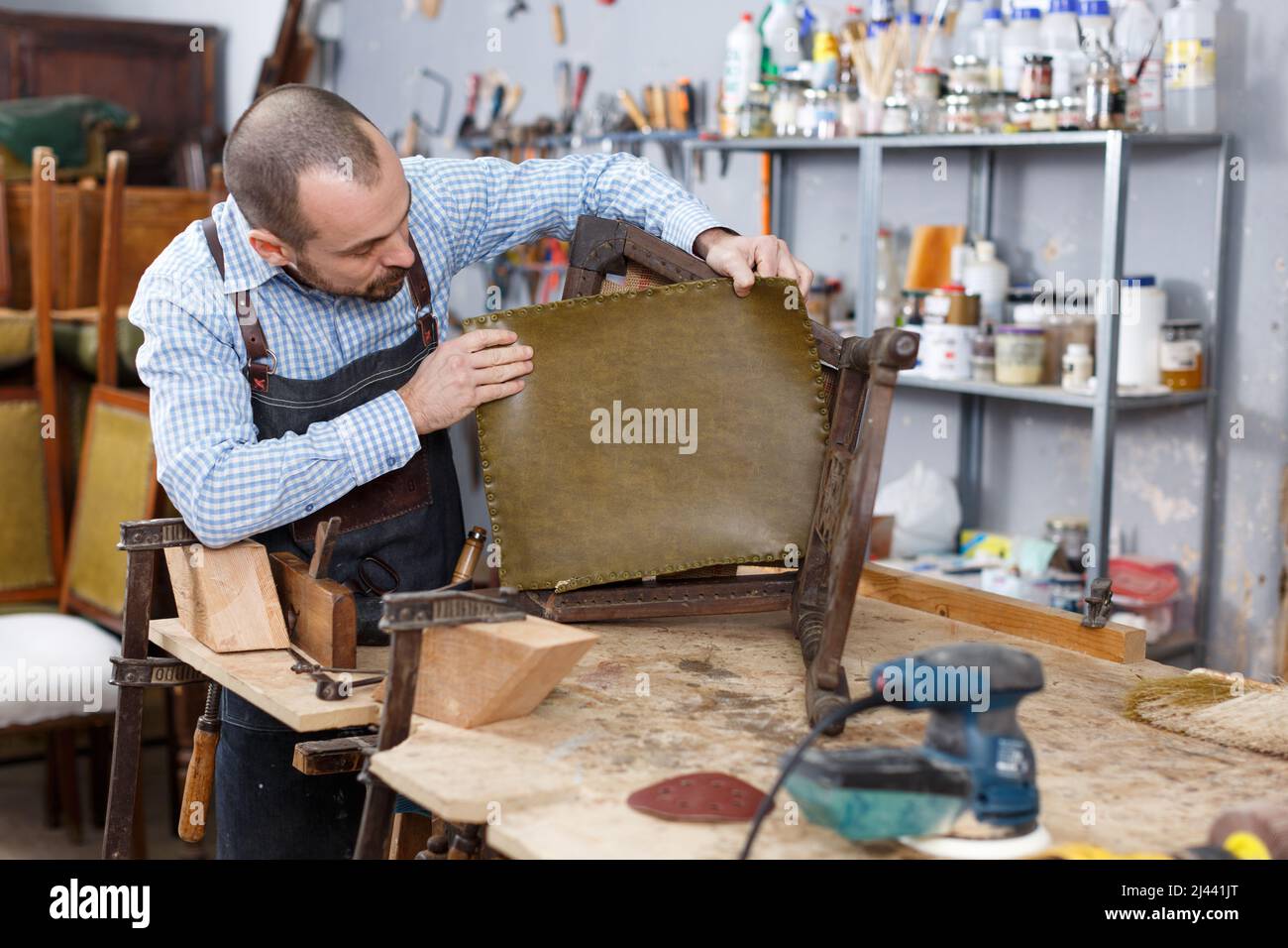 Restorer in process of renovation vintage armchair Stock Photo - Alamy