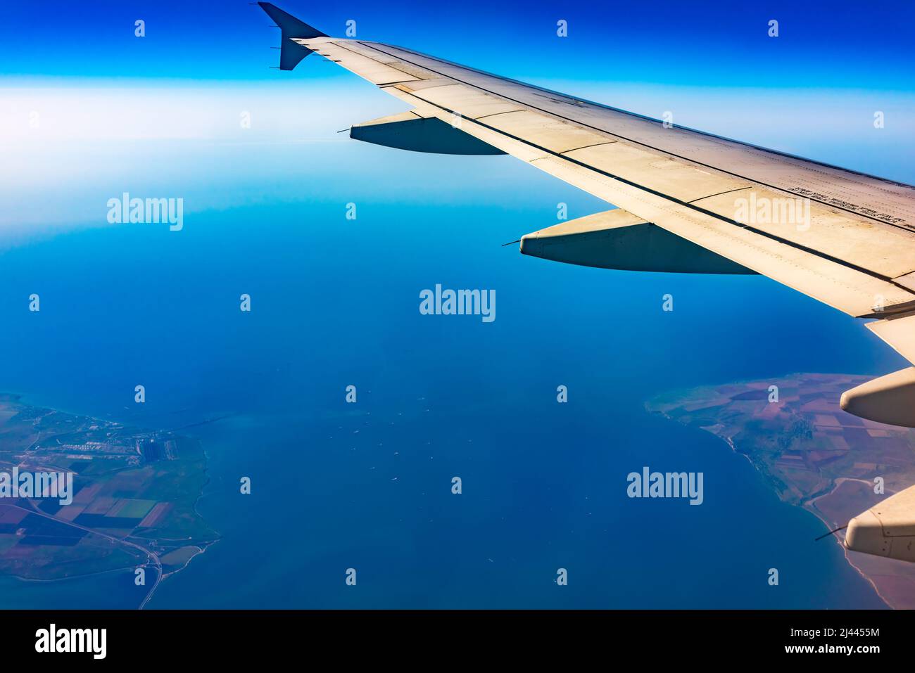View from the airplane window at a beautiful blue clear sky, earth, sea ...