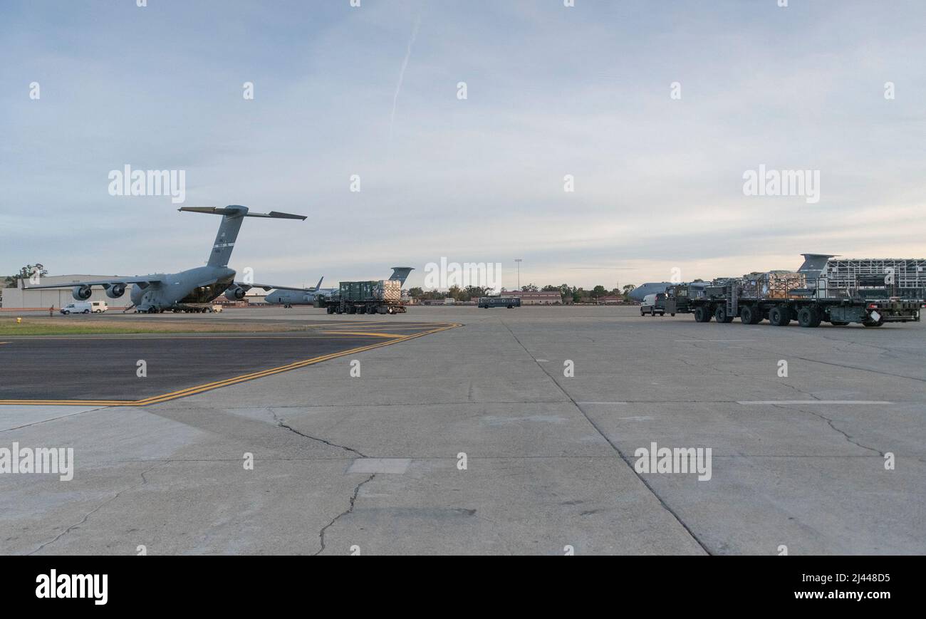 Tunner 60K aircraft cargo loaders prepare to off load cargo onto a U.S ...