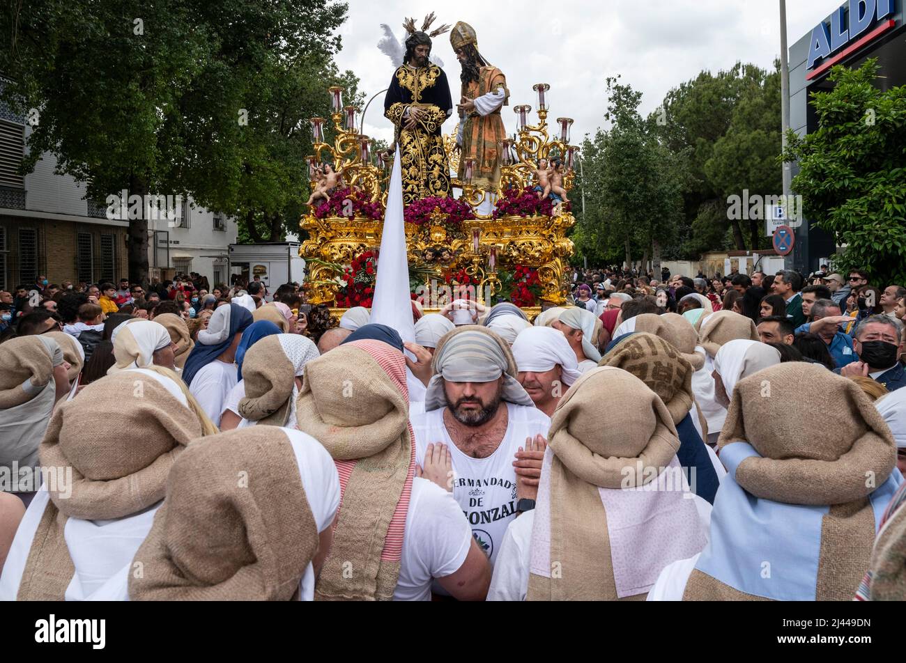 Penitents march during a procession as they carry the image of Jesus in ...