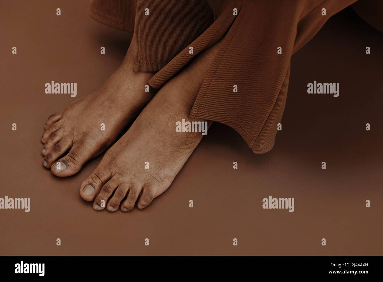 Close-up of barefooted feet of woman isolated on brown background Stock ...