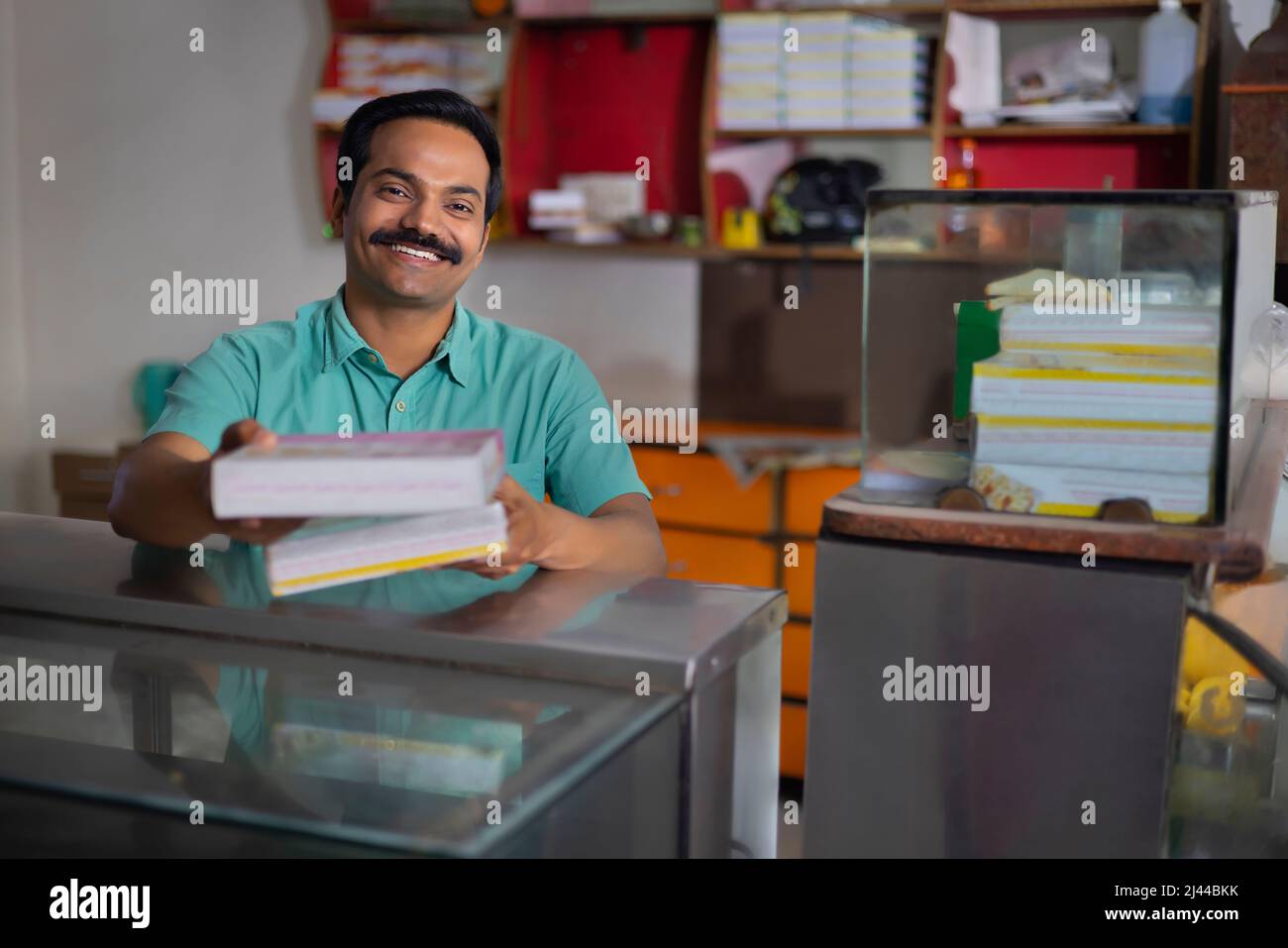 Sweet shop owner selling sweet to customer Stock Photo - Alamy