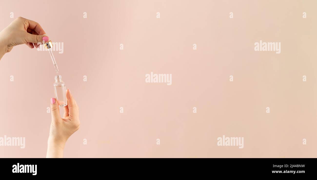 Banner female hands drip oil with a pipette inside a dropper with a ...